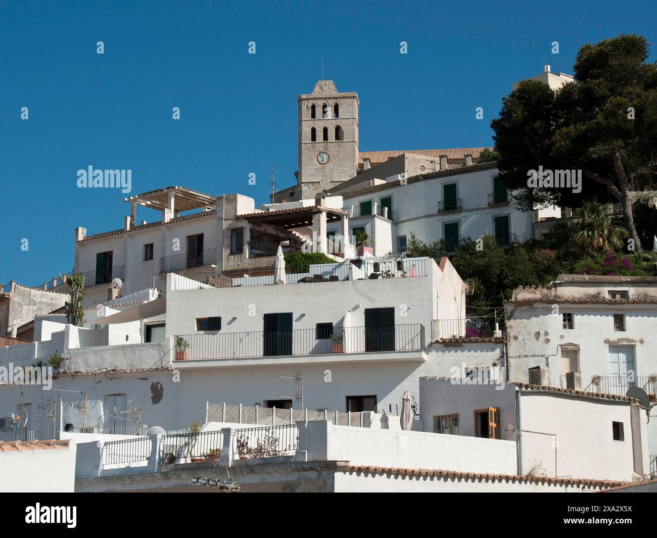 A picturesque old town with white buildings and a church under a summer ...