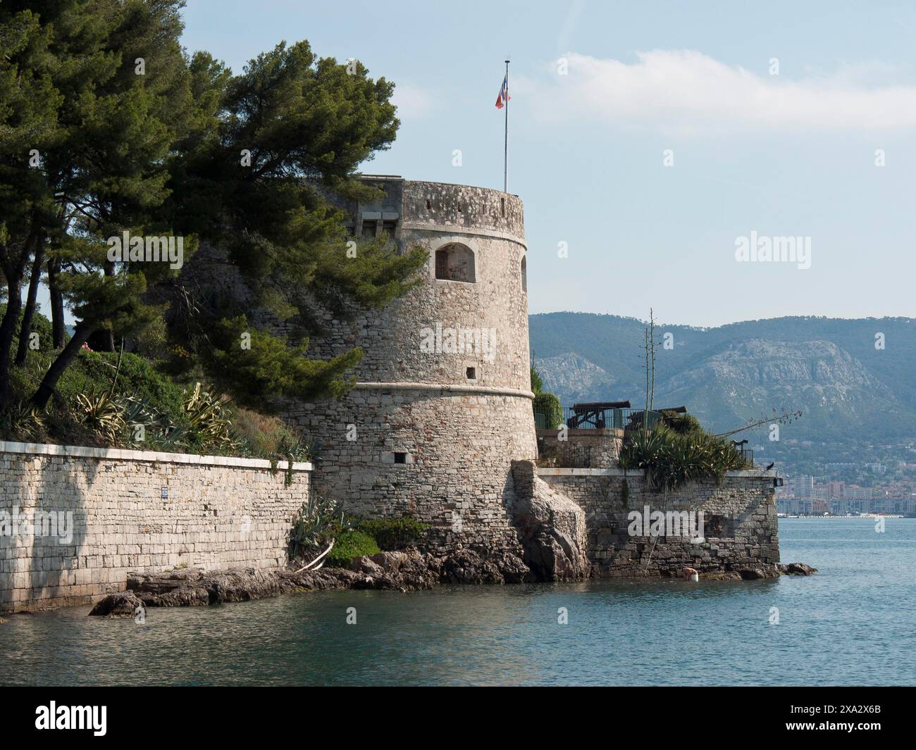 Historic fortress by the sea, with stone walls and flag, surrounded by ...