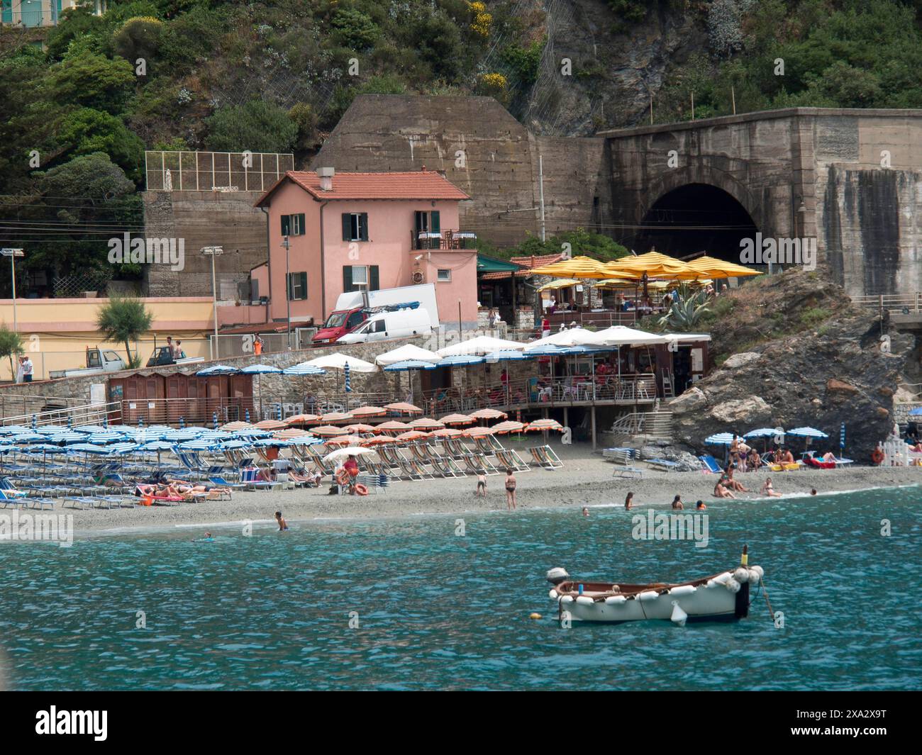Beach and coastline with buildings and parasols, surrounded by rocky ...