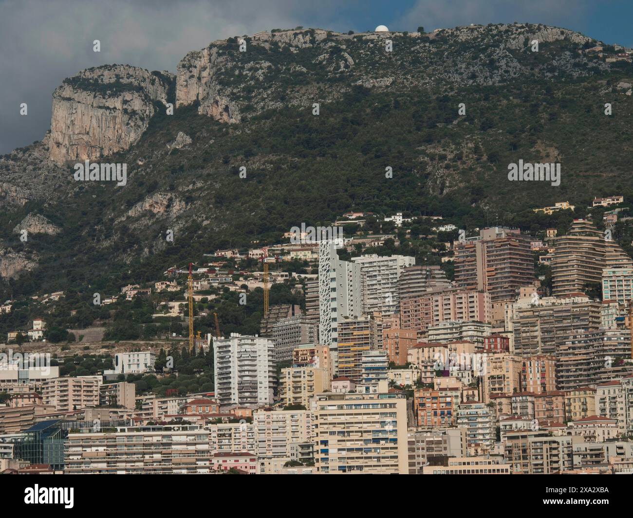A mountain landscape with a city full of buildings and clouds in the ...