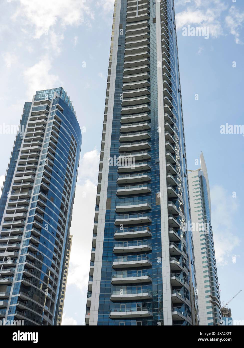 Three modern high-rise buildings with many balconies in front of a ...