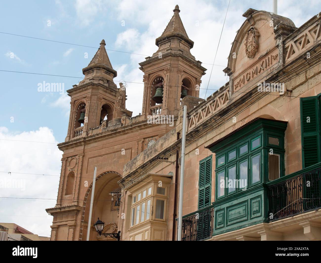 Historic church building with two bell towers and green shutters under ...