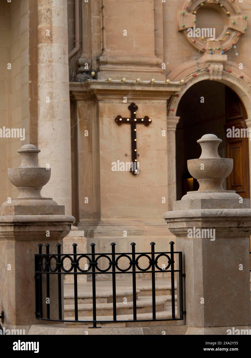 Decorative stone pillars and a black cross on a sandstone church ...