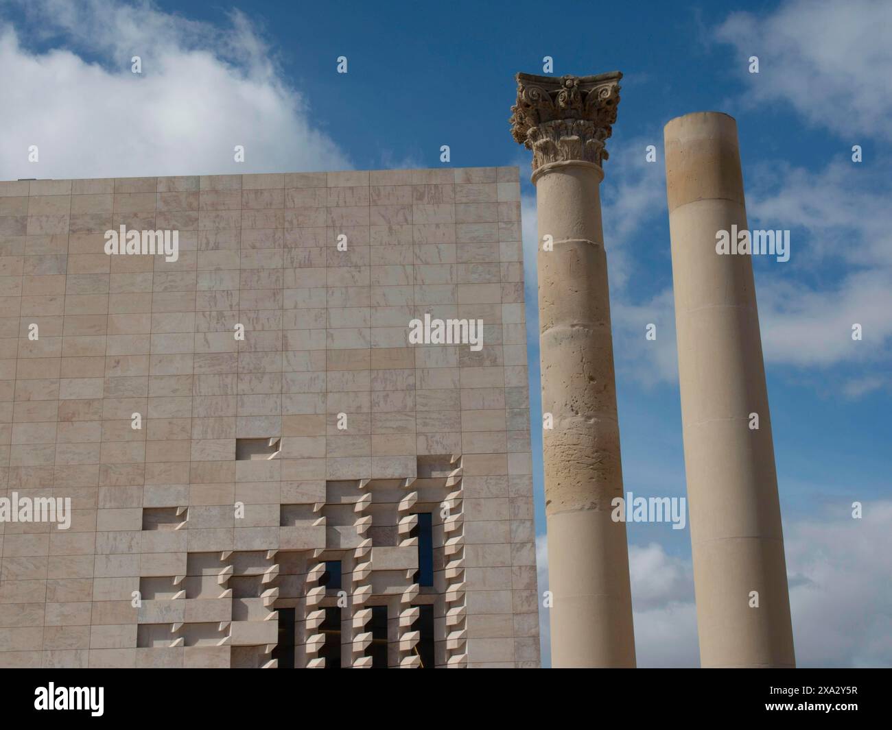 Two columns in front of a modern building with a fragment of ancient ...