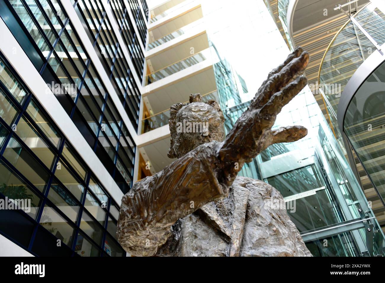 Large bronze statue in front of the glass facade of a modern office ...