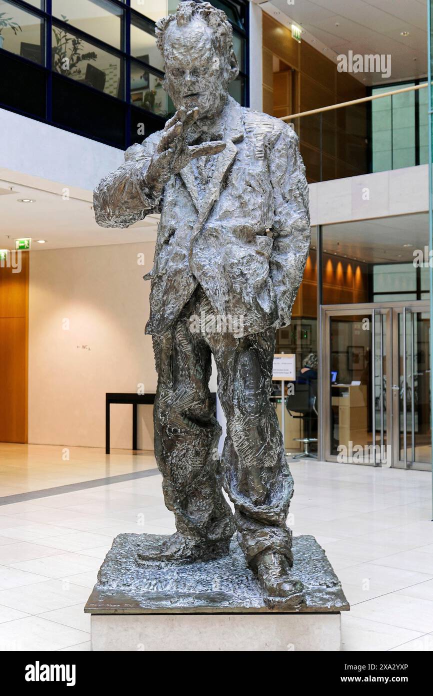 A bronze sculpture of a standing man in a modern style in a bright ...