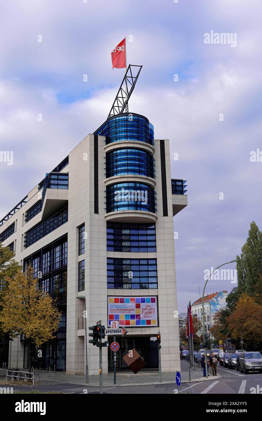 A modern office building on a street corner with a flag and autumnal ...