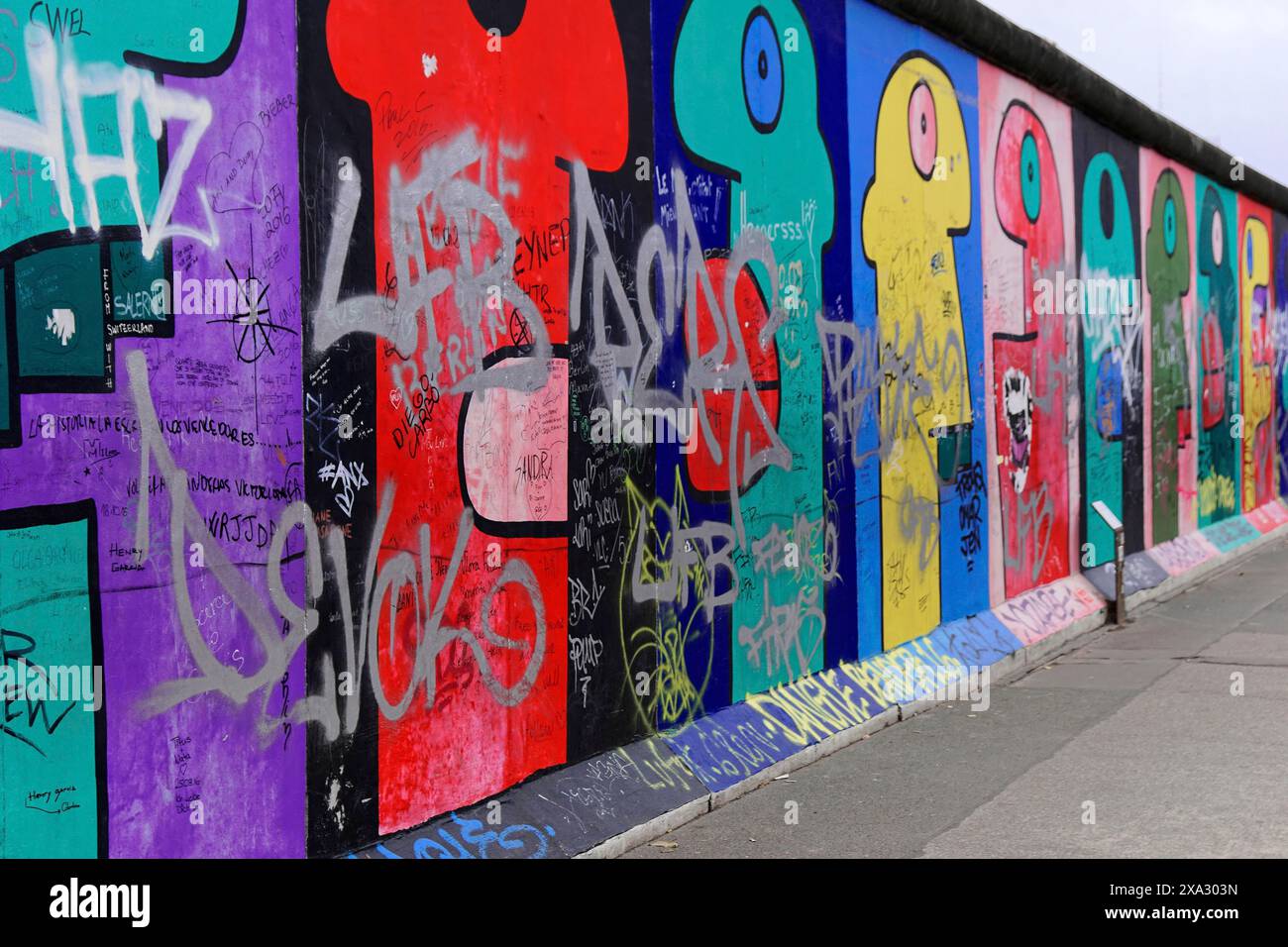 Long wall with colourful graffiti and inserted texts and symbols, mural ...