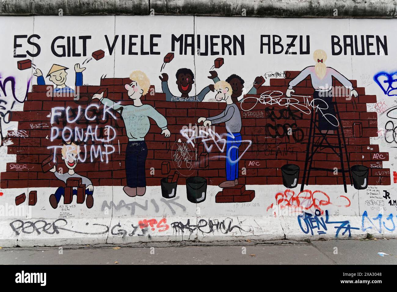 Murals of children building a wall, with political message and graffiti ...