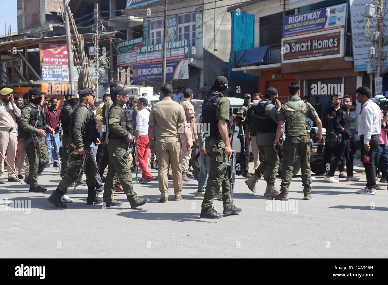 Police personnel managing a crowd in an urban street, ensuring security ...