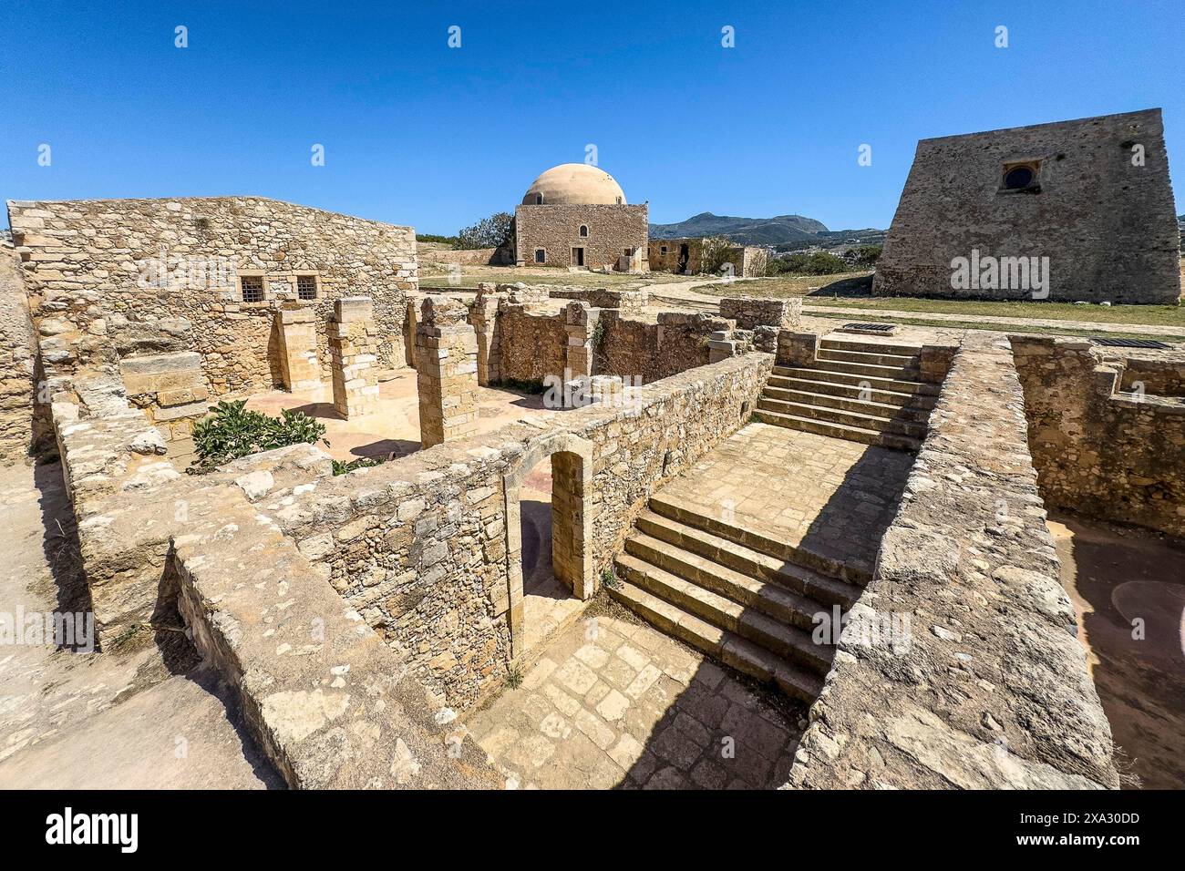 View of exposed walls columns of former storerooms and stairs to ...