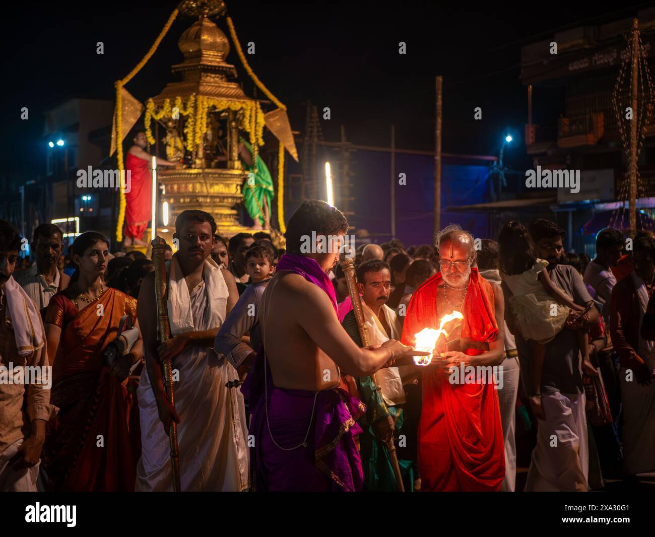 Udupi, INDIA - December 26, 2024 : Temple priest during Krishna temple rath yatra where large ...