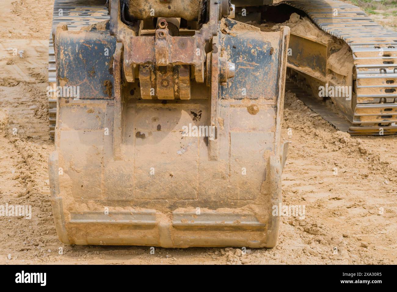 Front view of bucket on backhoe parked at rural construction site in ...