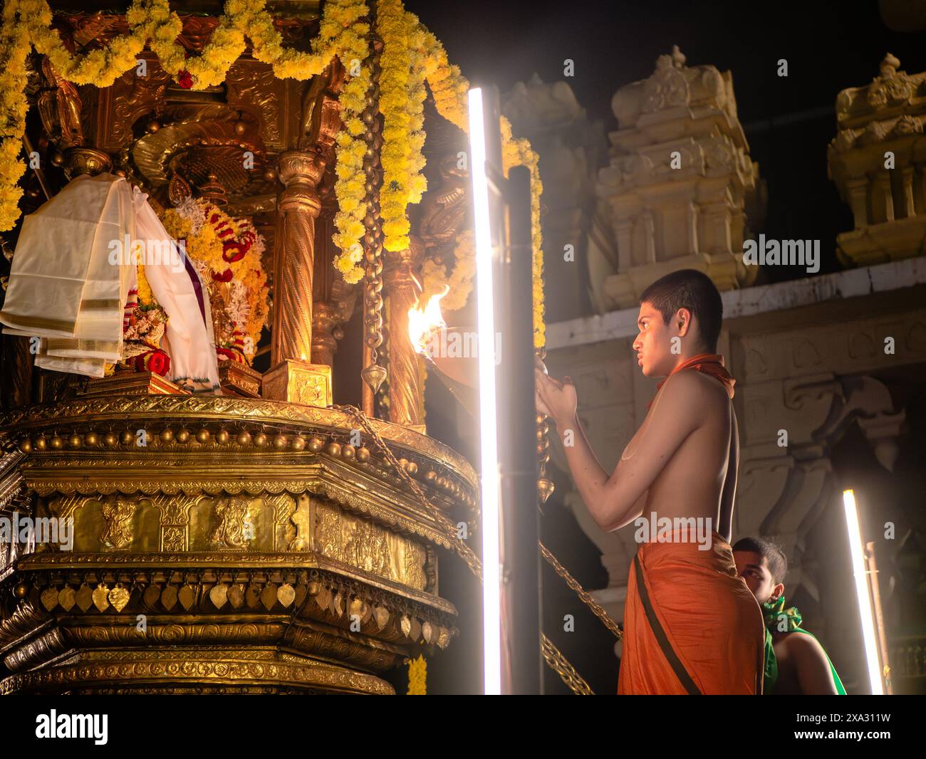 Udupi, INDIA - December 26, 2024 : Temple priest during Krishna temple rath yatra where large ...