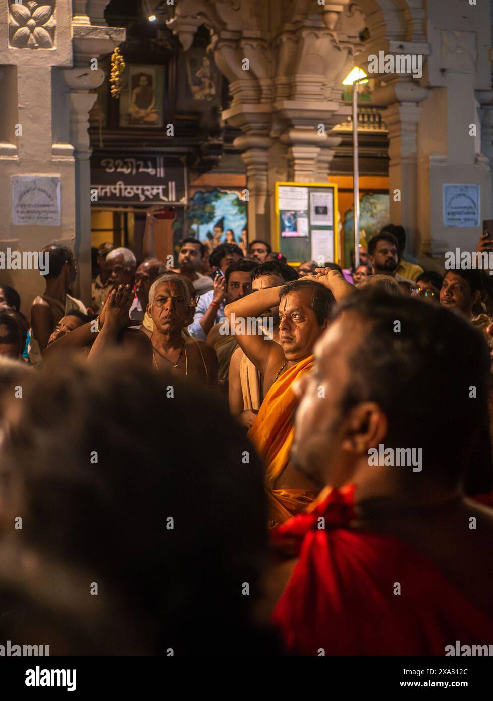 Udupi, INDIA - December 26, 2024 : Temple priest during Krishna temple rath yatra where large ...