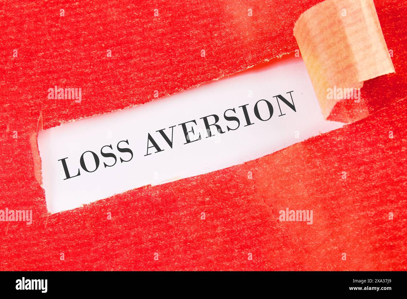 Business concept. LOSS AVERSION text under the torn paper on a white ...