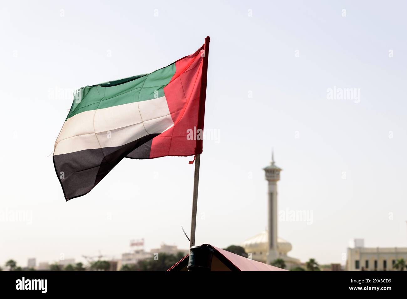 The UAE flag, flying the breeze, on Dubai Creek with the old district ...
