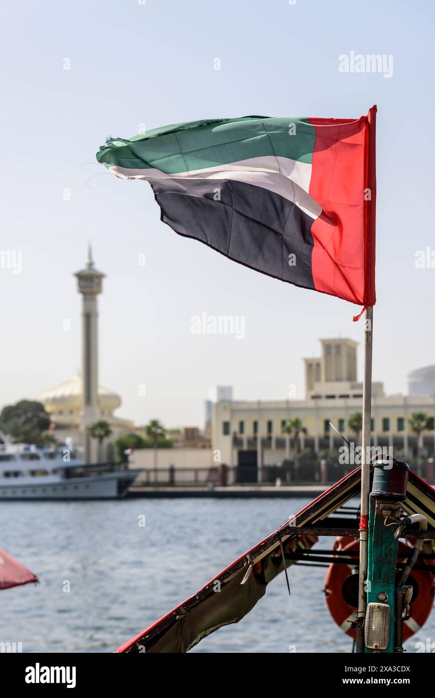 The UAE flag, flying the breeze, on Dubai Creek with the old district ...