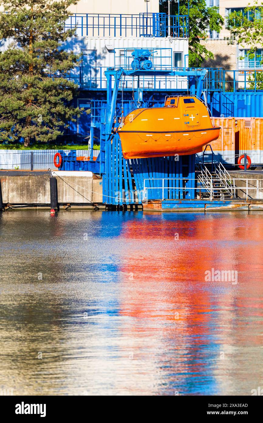 orange rescue boat in the seaport, vertical photo. suspended rescue ...
