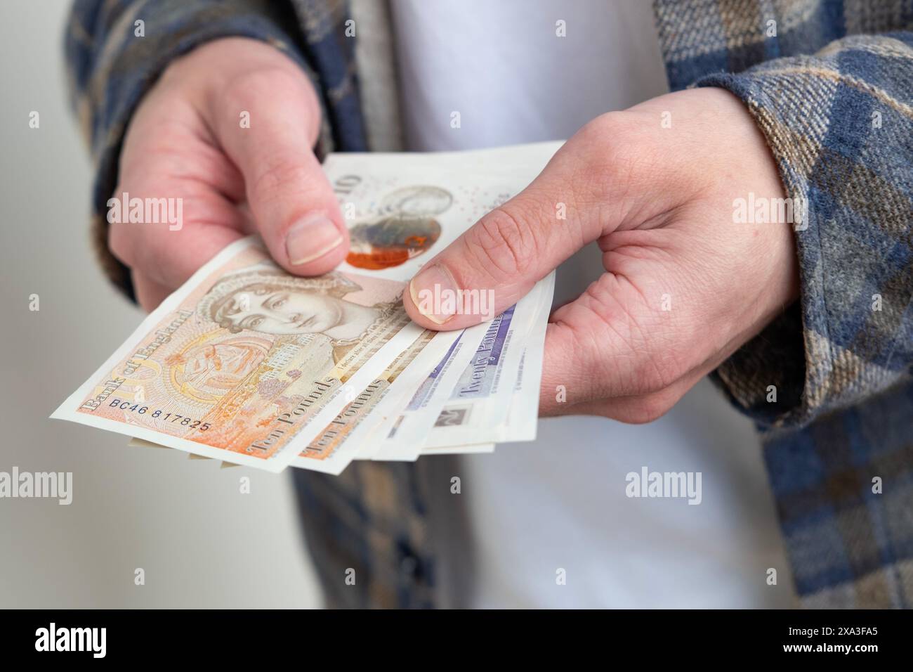 male hands holding money, counting English pound sterling bills ...