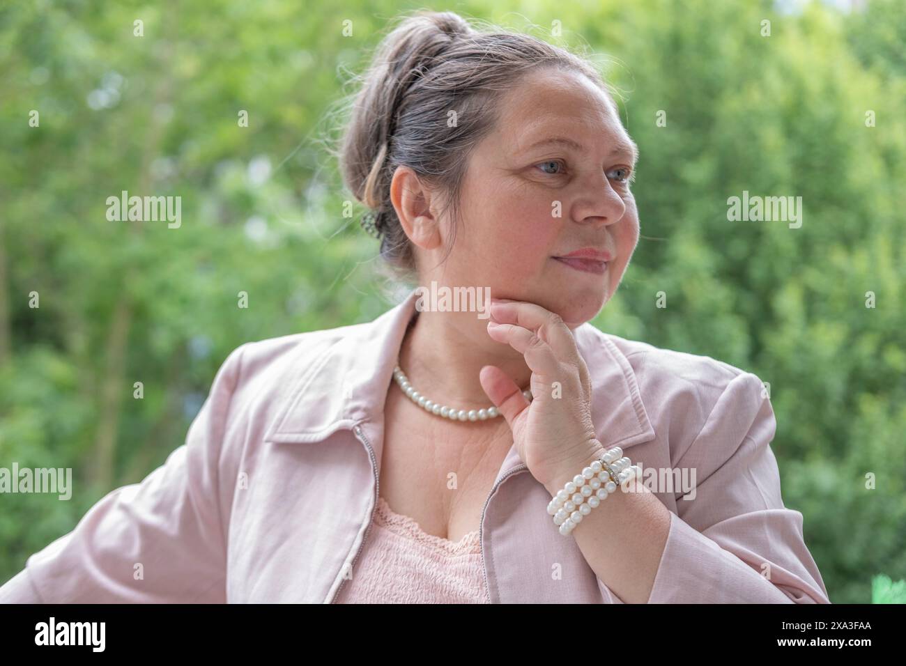 poised and elegant mature woman in pink blazer showcases enduring beauty and grace self-assured ...