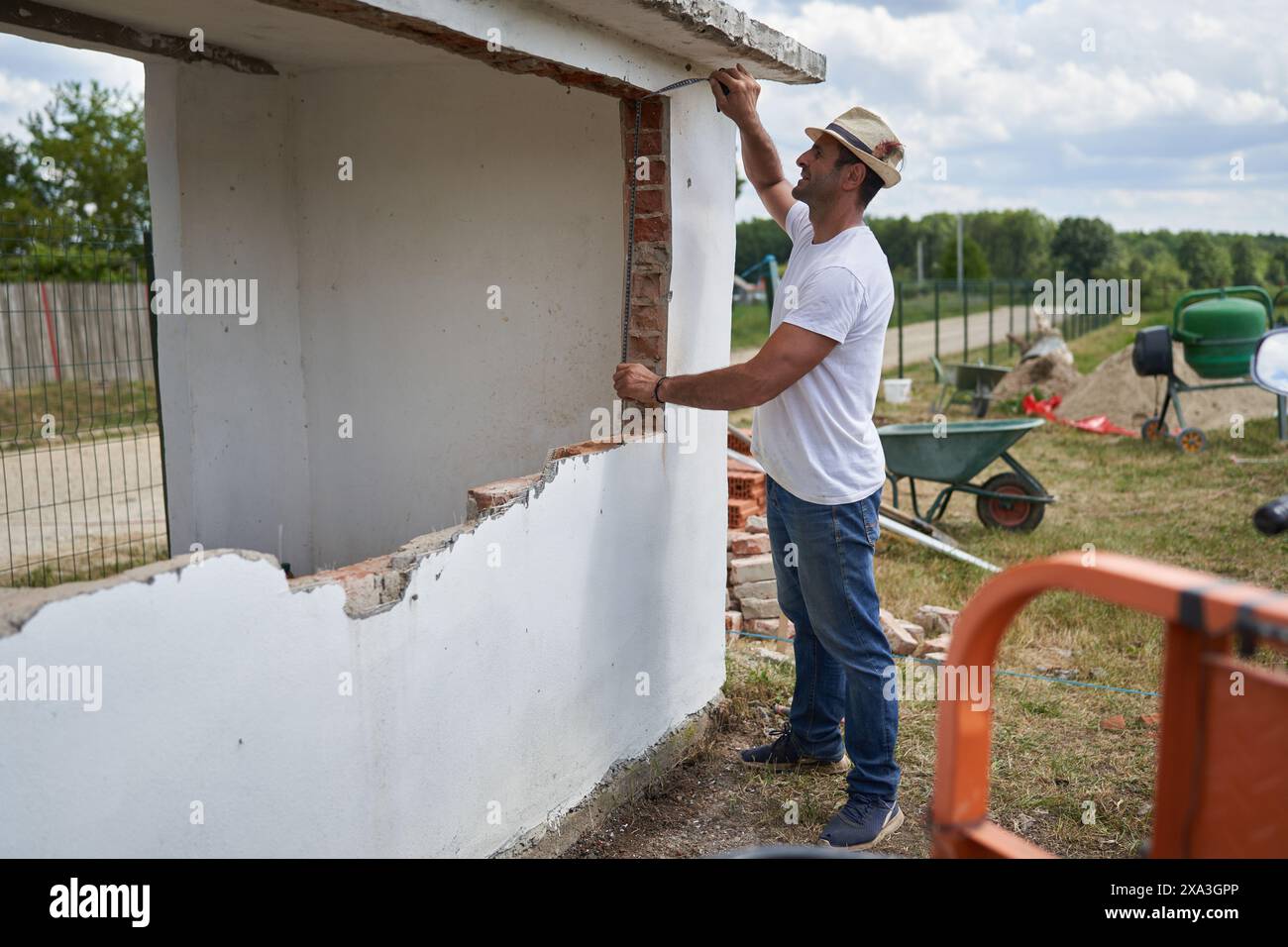 Indian man building a shed outdoor by the side of a lavender plantation ...