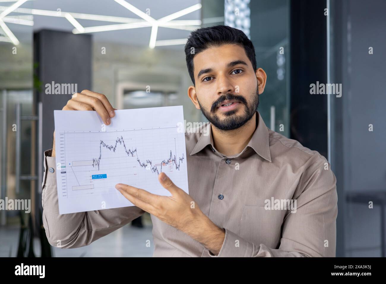 Professional businessman holding a financial chart, explaining market ...