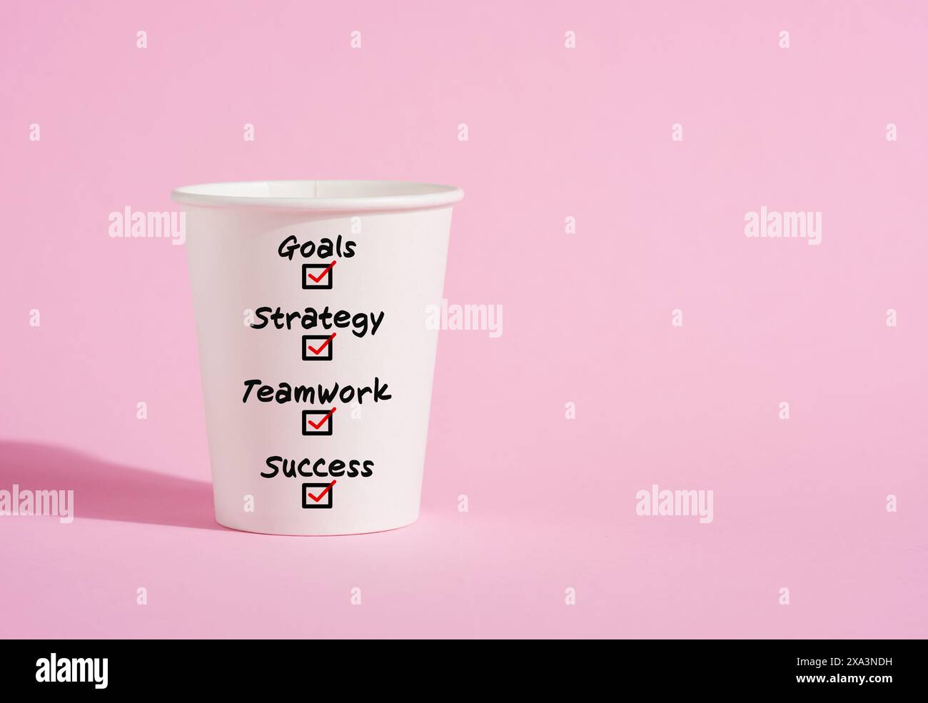 Goal, strategy, teamwork and success on a paper coffee cup on pink ...