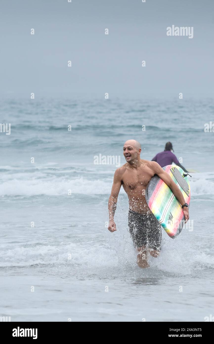 A happoy laughing surfer running out of the sea during the Sand Bandit ...
