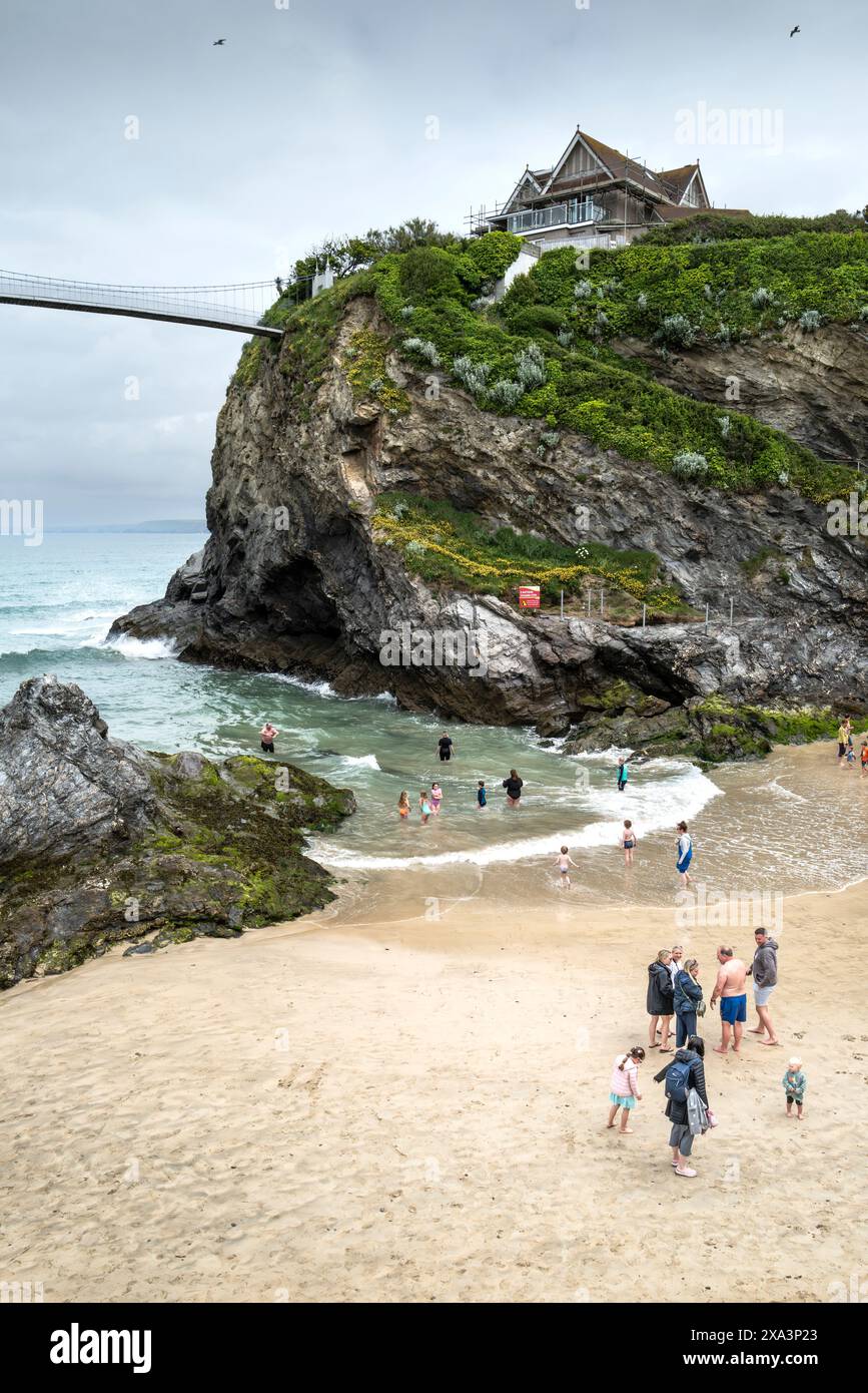 Holidaymakers relaxing and having fun in the sea and on the beach at ...