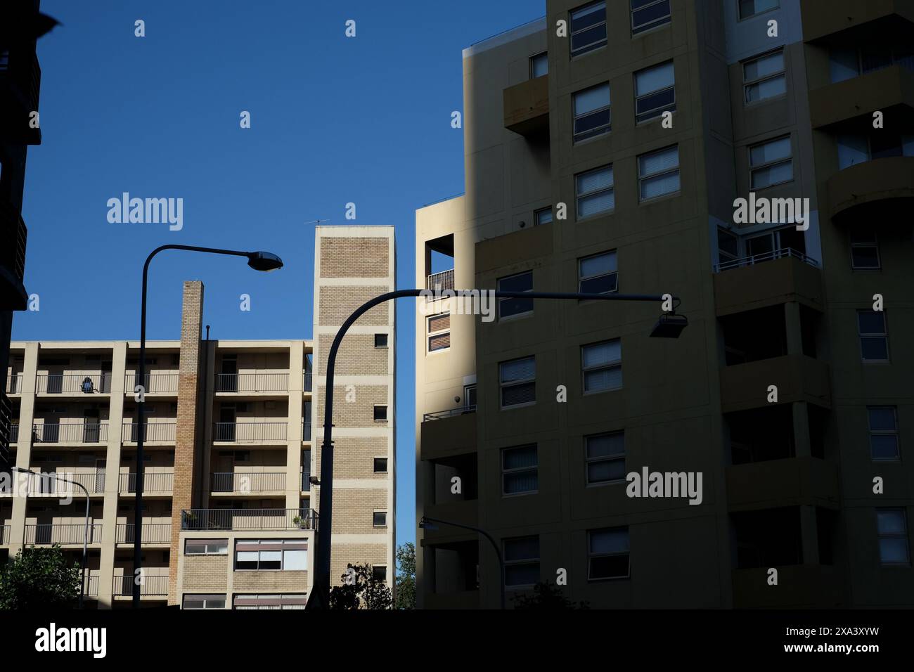 Abstract forms, light poles, apartment buildings, a square brick tower ...