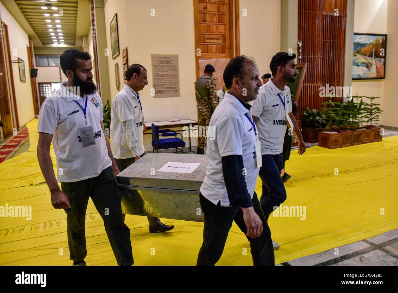 Electoral officials carry a box full of Electronic Voting Machine (EVM ...