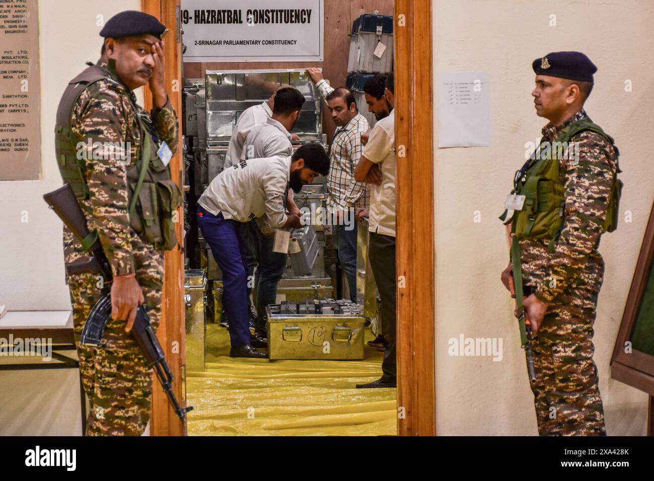 Electoral officials carry an Electronic Voting Machine (EVM) at a ...