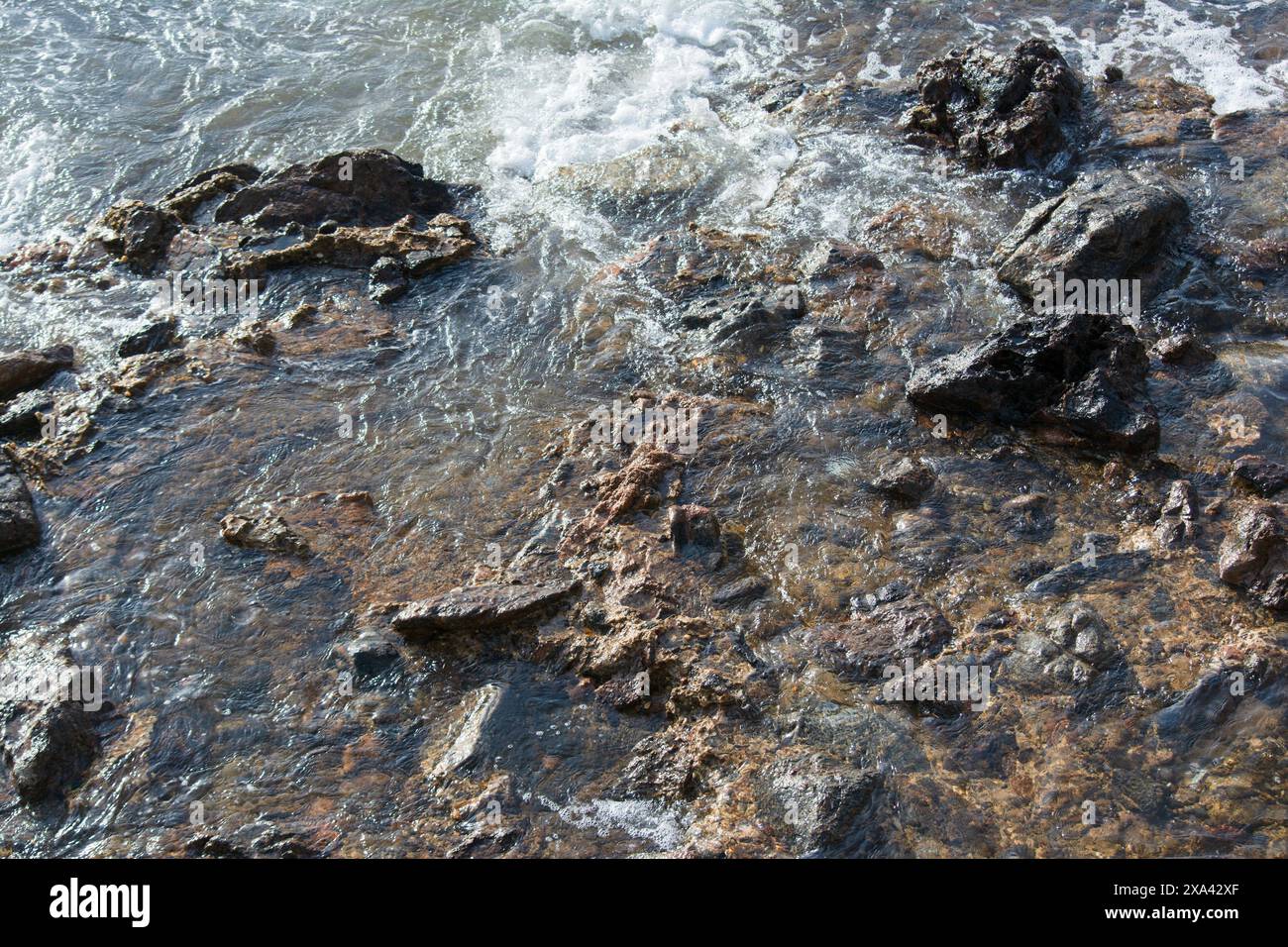 Dark rocks on a beach. Preserved nature Stock Photo - Alamy