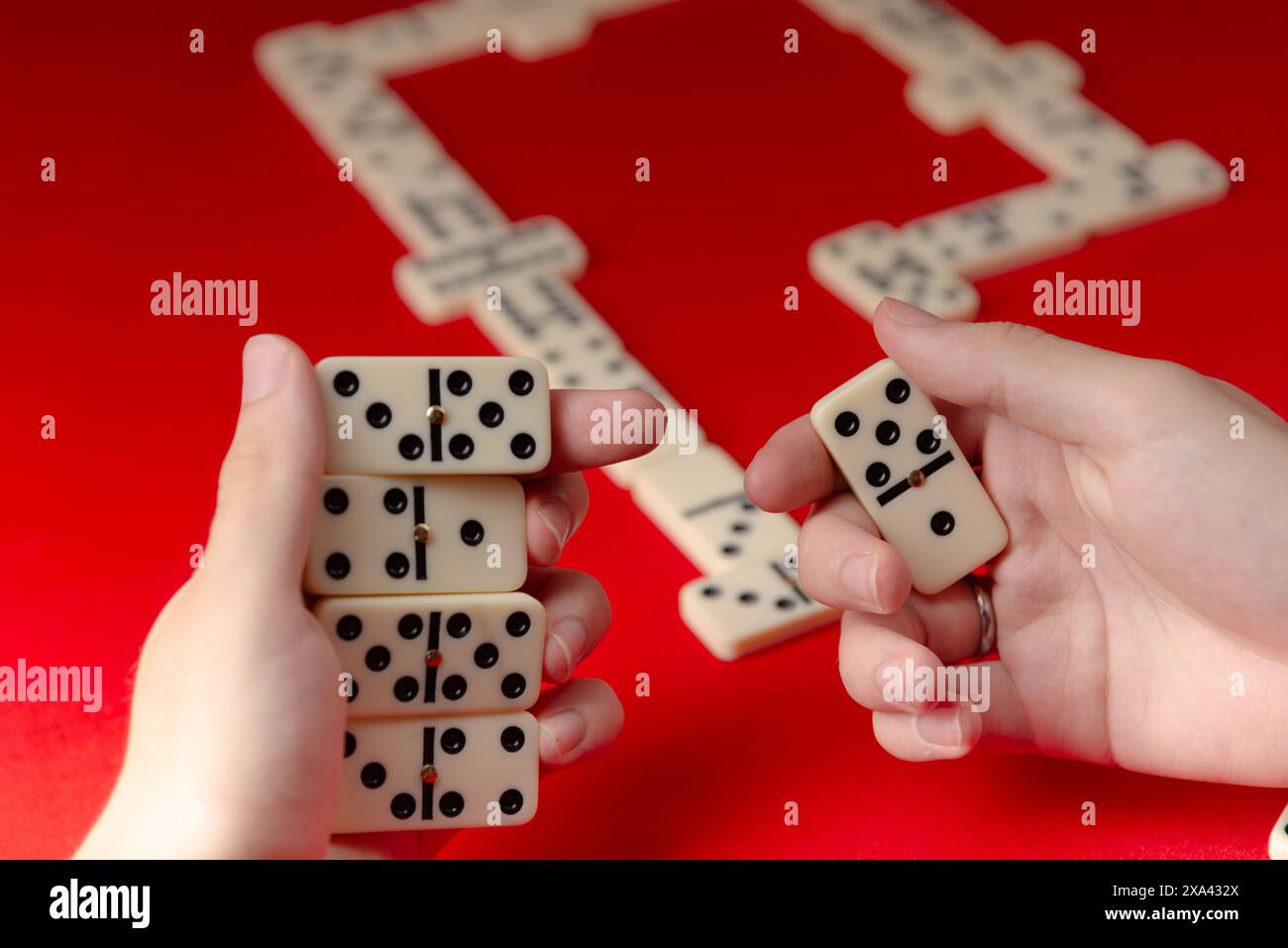 Domino players hands holding rectangular number blocks. Board game. Red ...