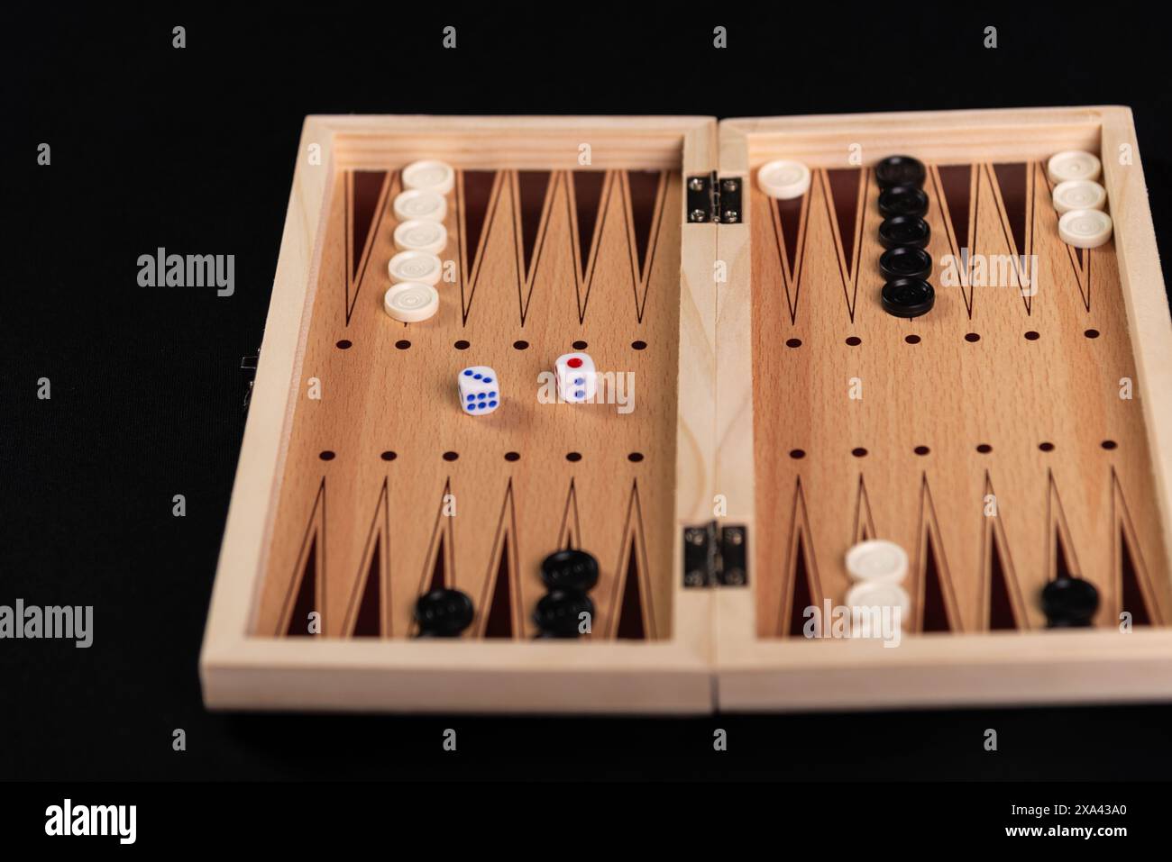 Board for playing backgammon with pieces and dice on a black background ...