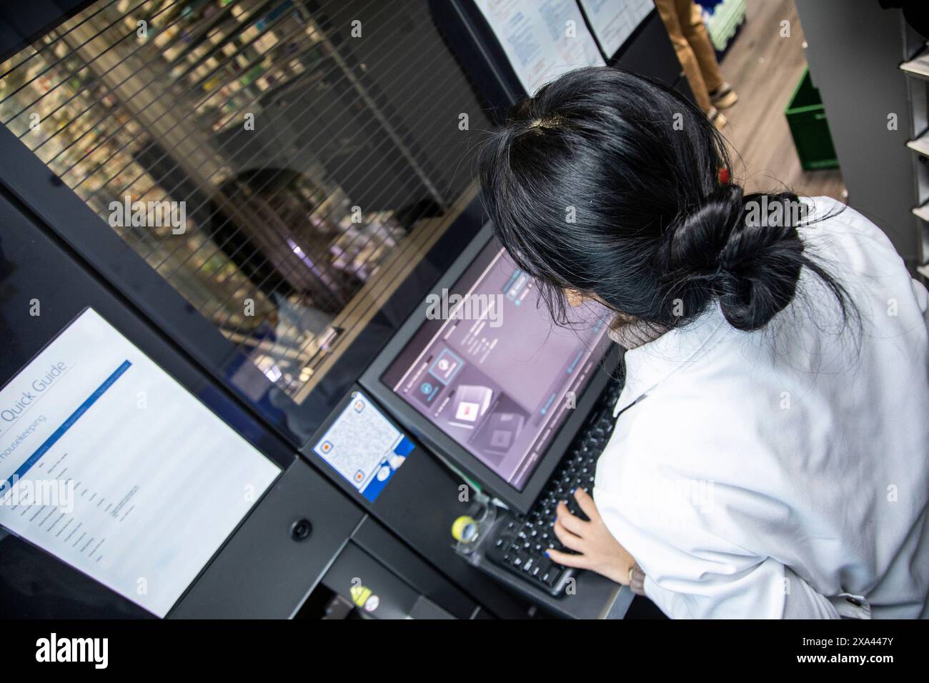 Woman working on a modern medical device with monitor and keyboard ...