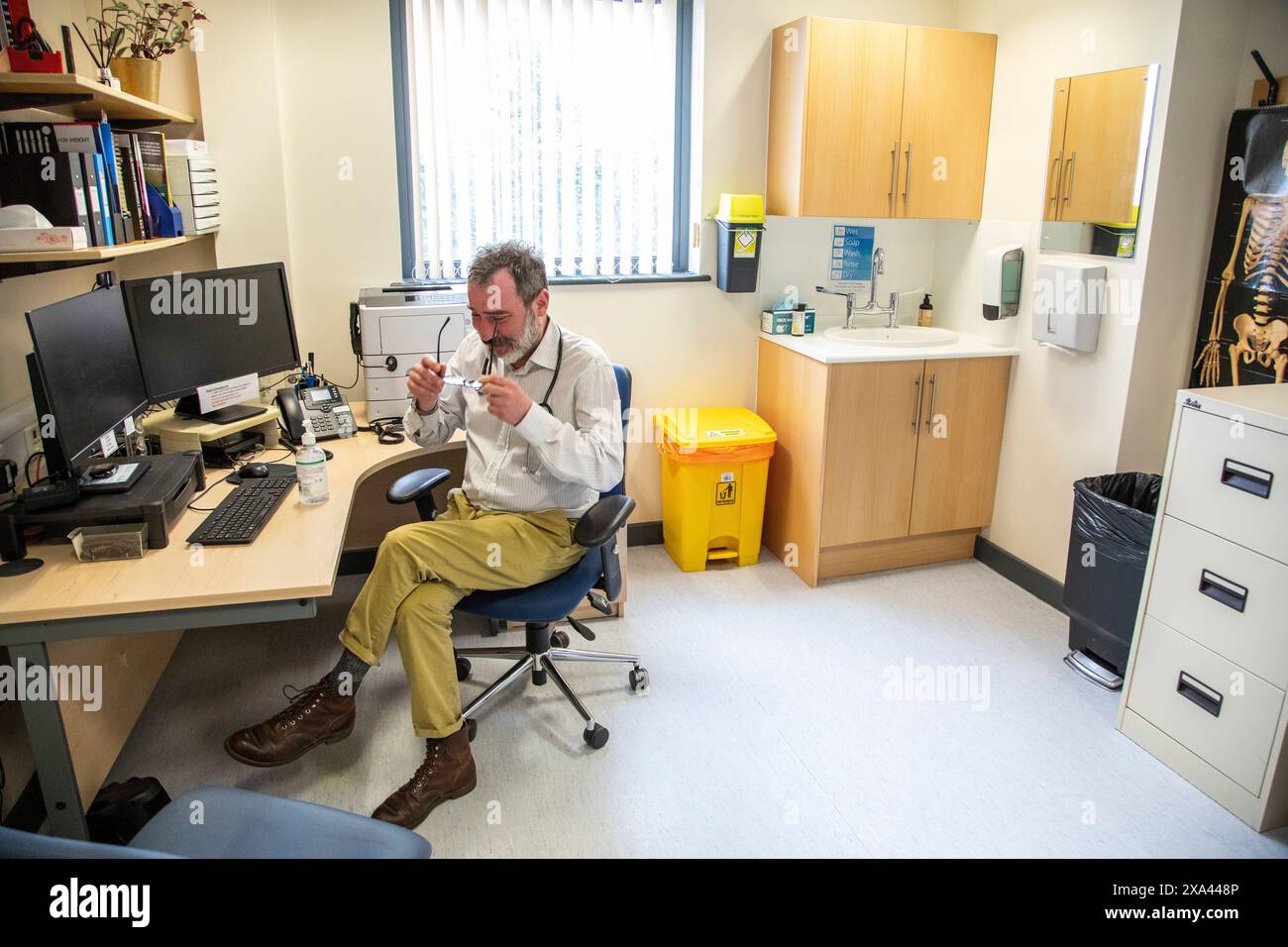 Doctor working at a desk in a medical office Stock Photo - Alamy