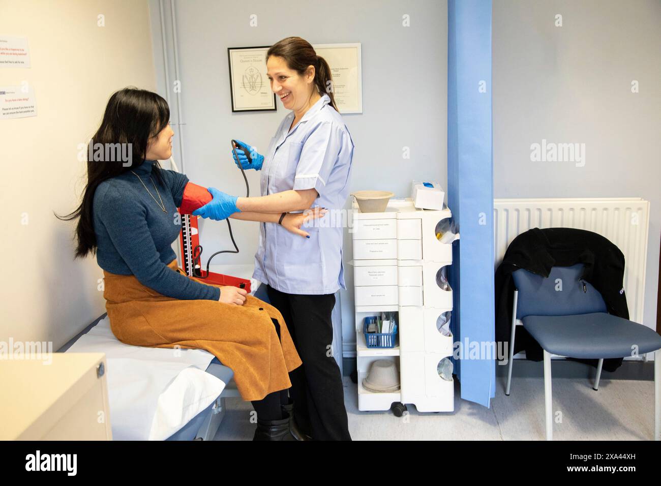 Nurse checking patient's blood pressure in clinic Stock Photo - Alamy