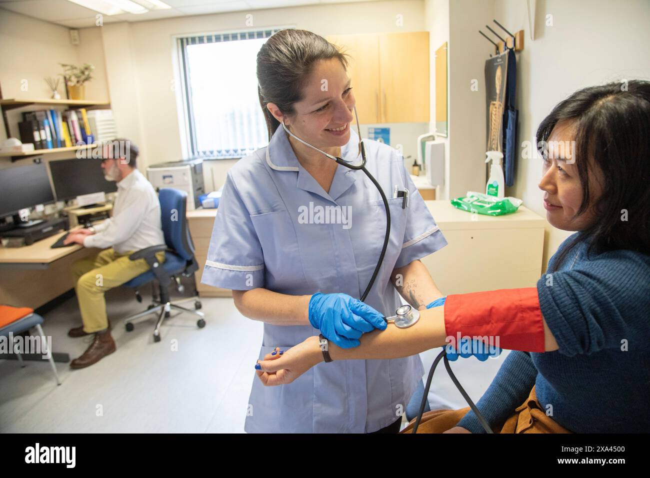 Nurse examining a patient's arm for blood pressure and pulse Stock ...