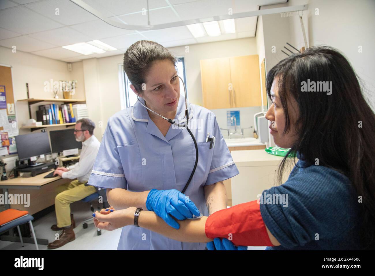 Nurse examining a patient's arm for blood pressure and pulse Stock ...