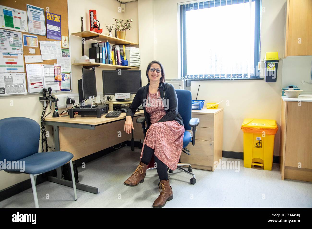 Doctor sitting office medical practicewith computer notice board hi-res ...