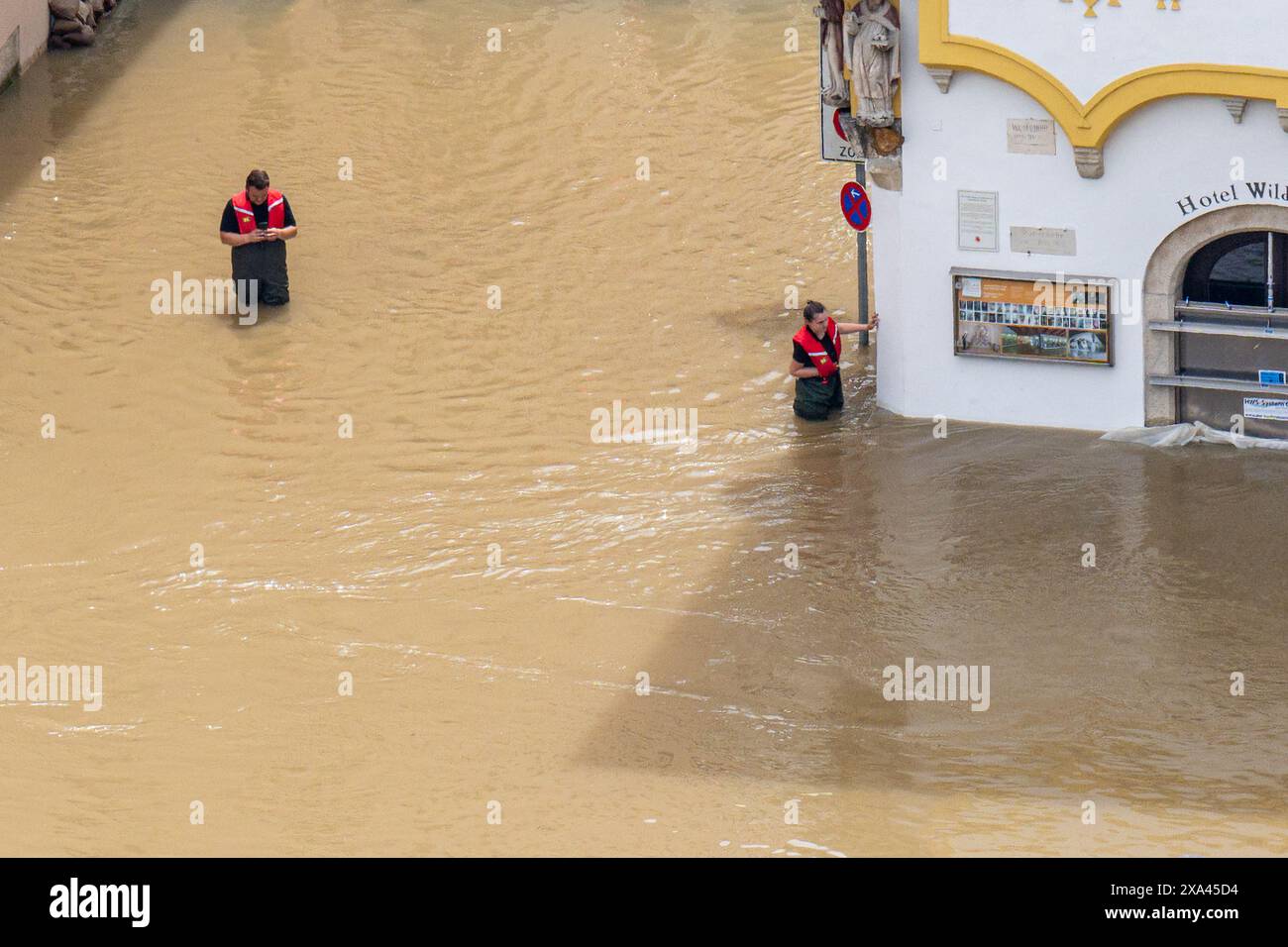 Passau, Germany. 04th June, 2024. Rescue workers stand in the flood ...