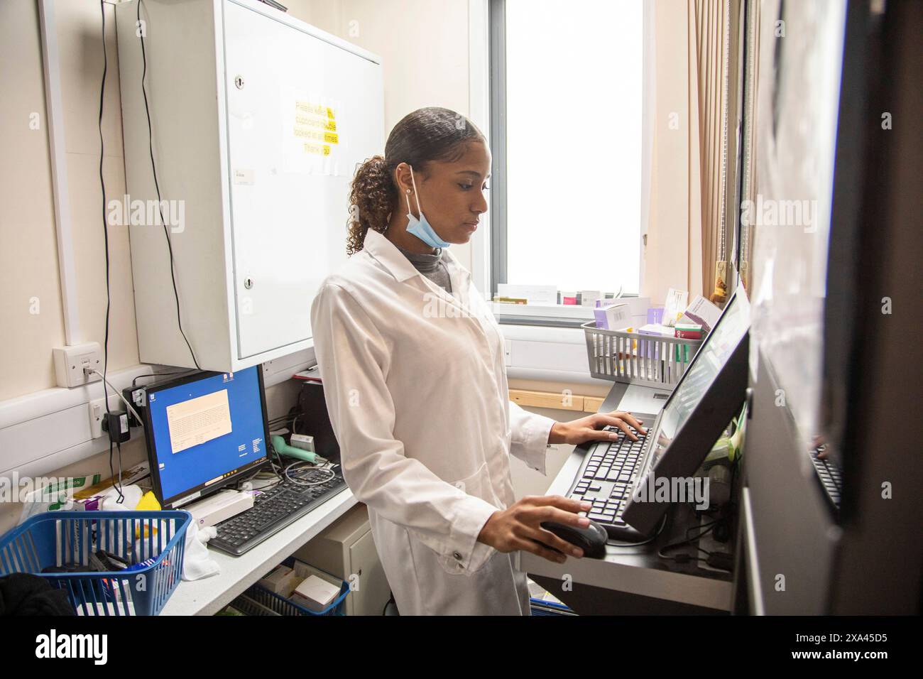 Female technician operating advanced machinery in a medical practice ...