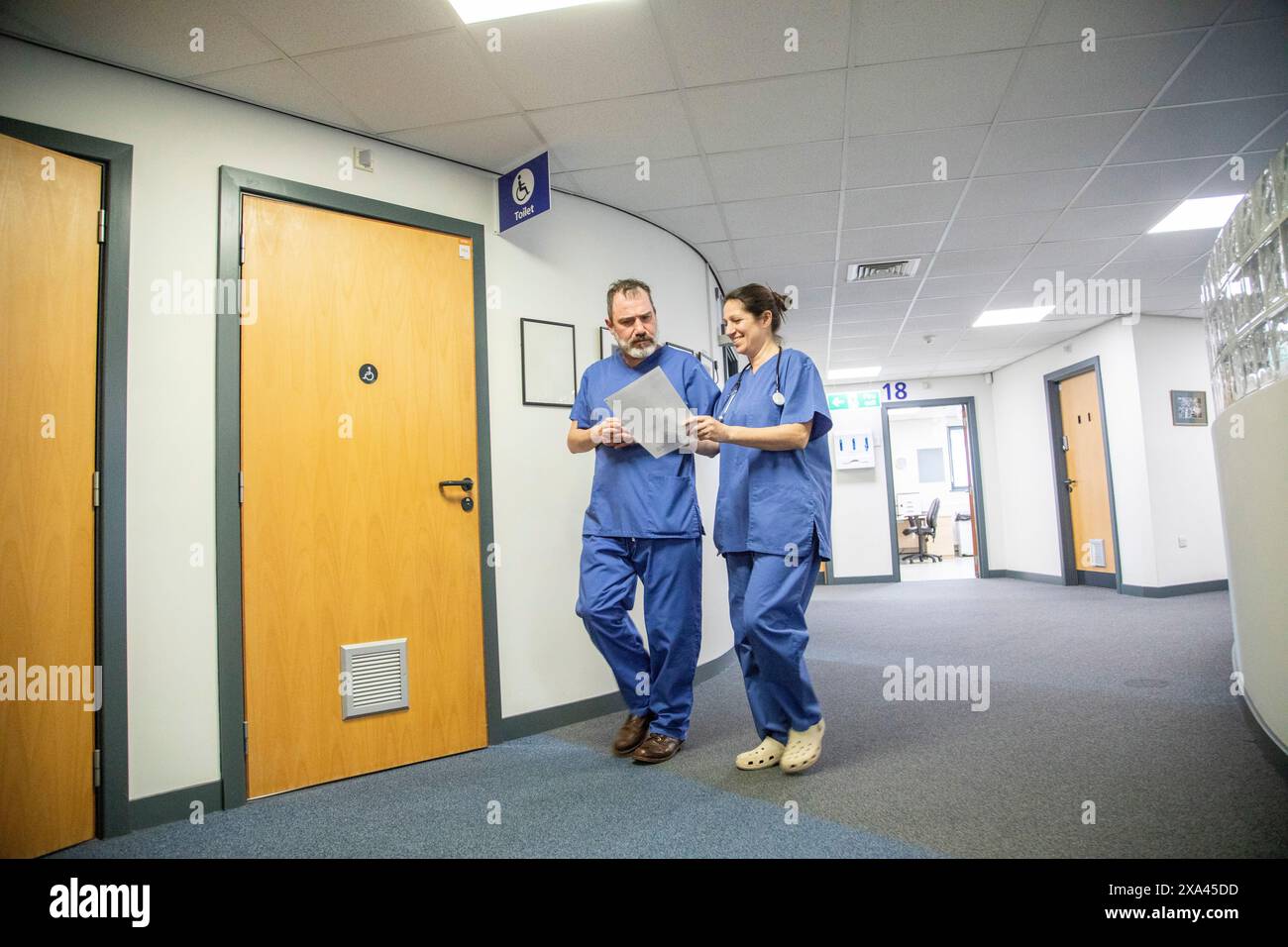 Two medical professionals walking through hospital corridor hi-res ...