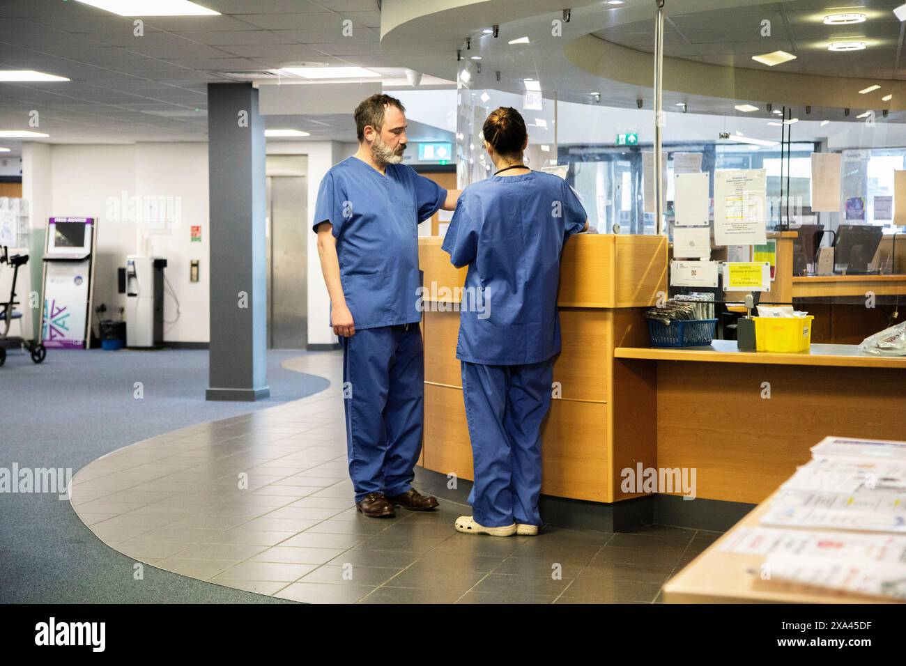 Healthcare workers conversing hospital reception area hi-res stock ...
