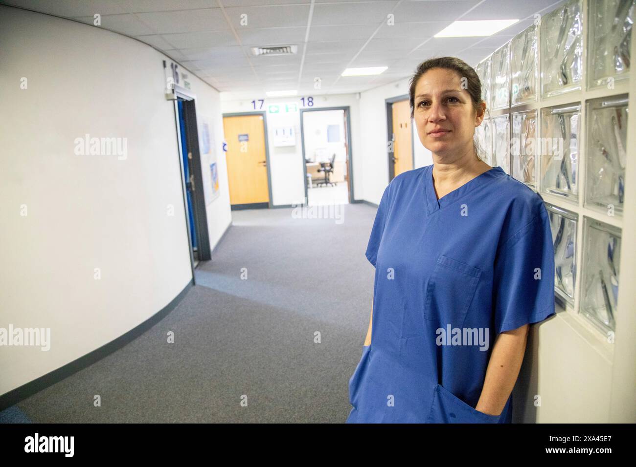 Medical professional standing in hospital corridor, medical practice UK ...