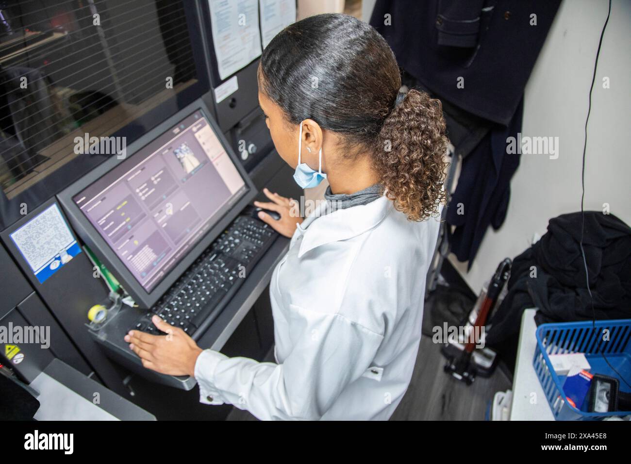 Female technician operating advanced machinery in a medical practice ...