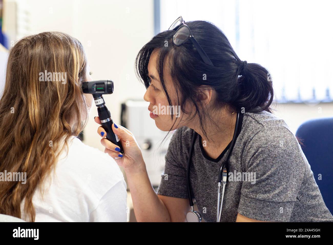 Doctor conducting an ear examination in a medical practice Stock Photo ...