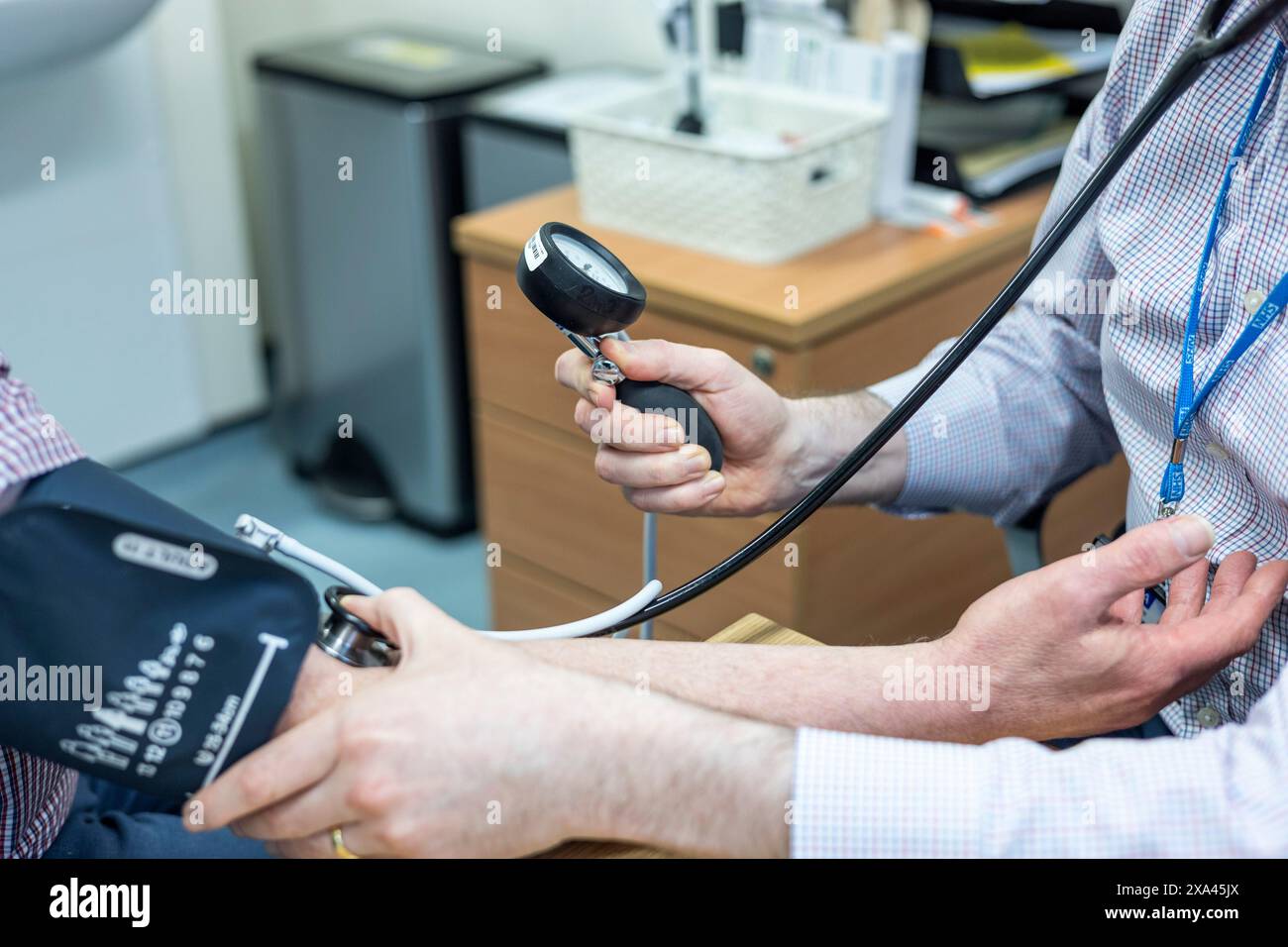 Doctor taking blood pressure reading for a patient Stock Photo - Alamy